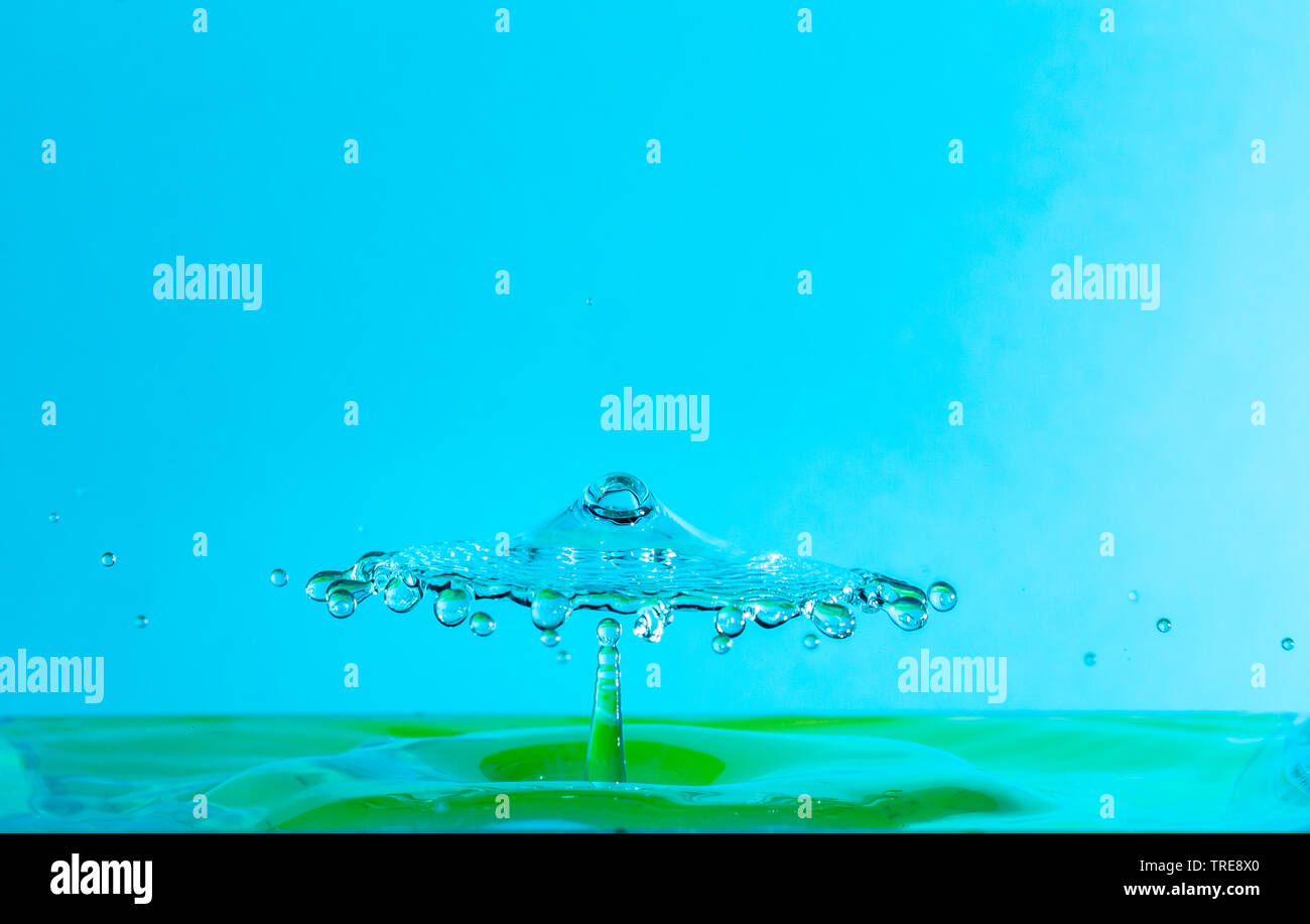 water drop falling and impacting a body of water after hitting the ...