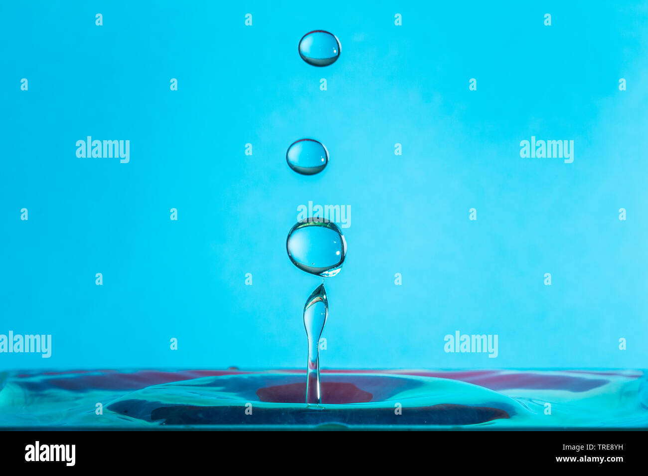 water drop falling and impacting a body of water after hitting the ...