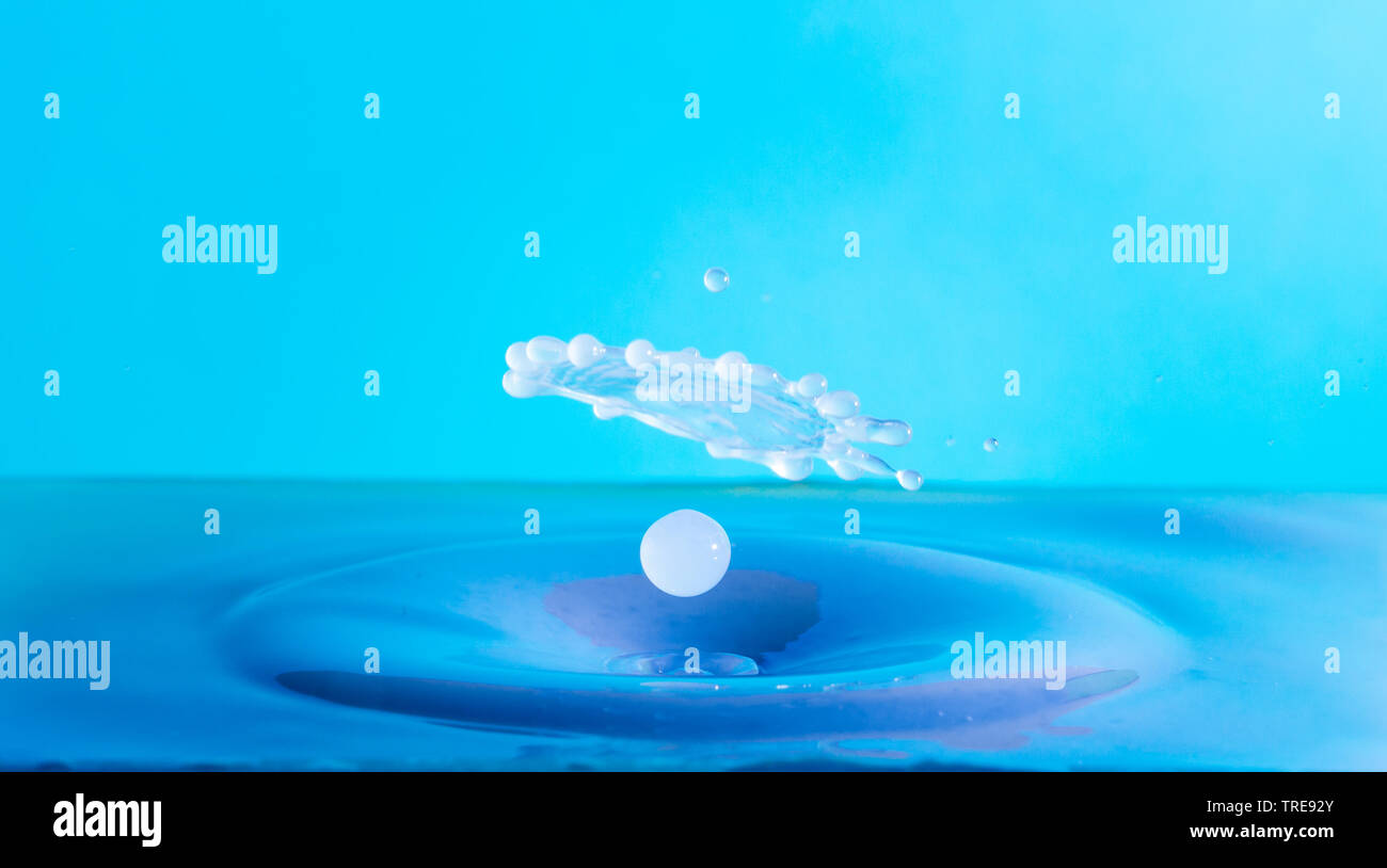 water drop falling and impacting a body of water after hitting the ...