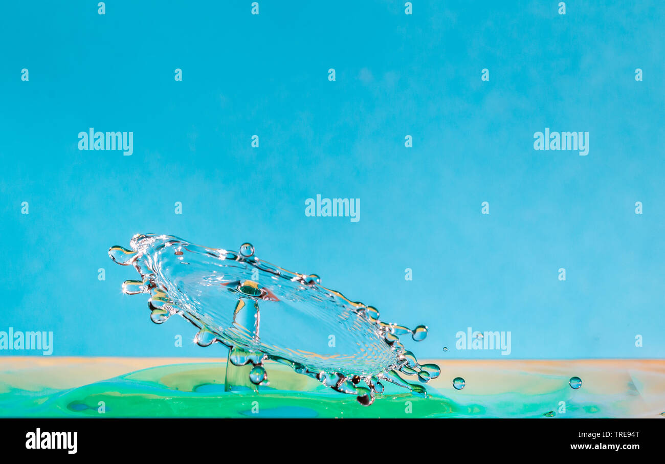 water drop falling and impacting a body of water after hitting the ...