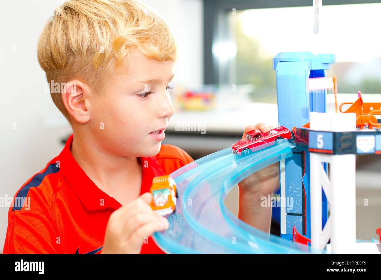 Young boy playing with cars in a toy parking garage Stock Photo - Alamy