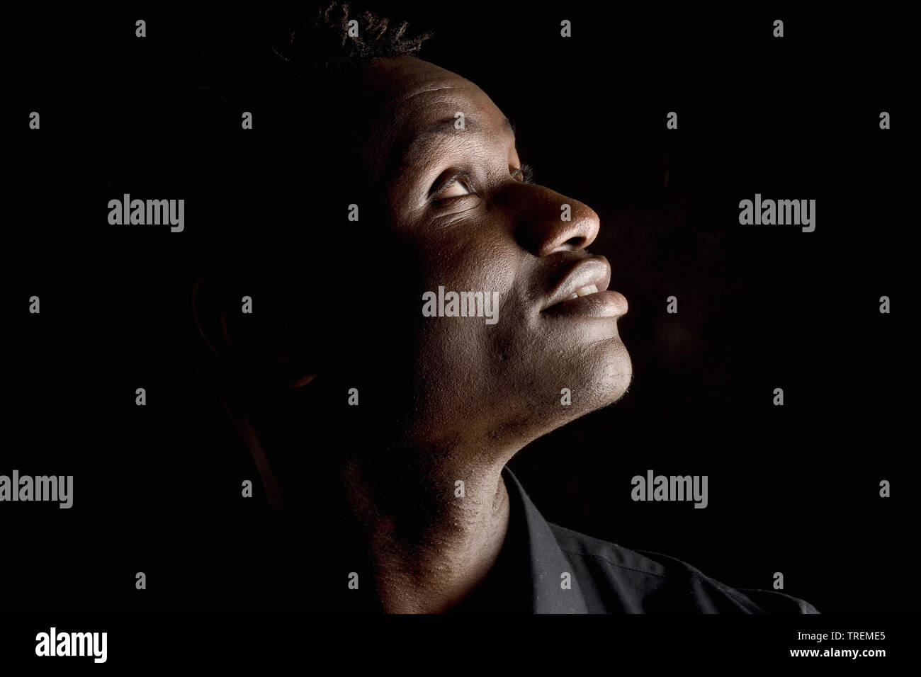 portrait of a african man look up on black background Stock Photo - Alamy