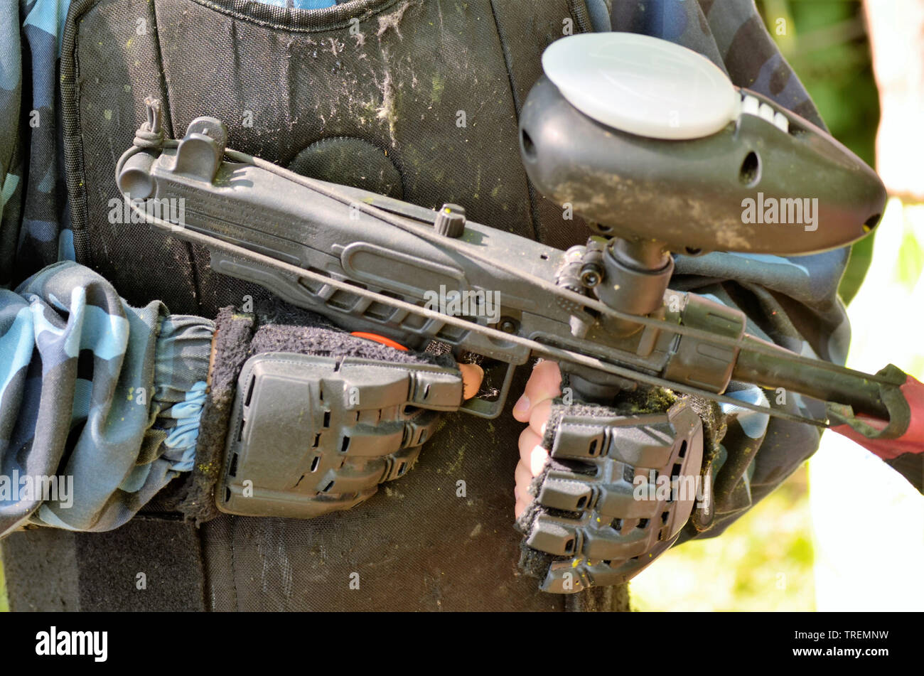 Paintball battle. Detail of the rifle held by a player: you can see the ...