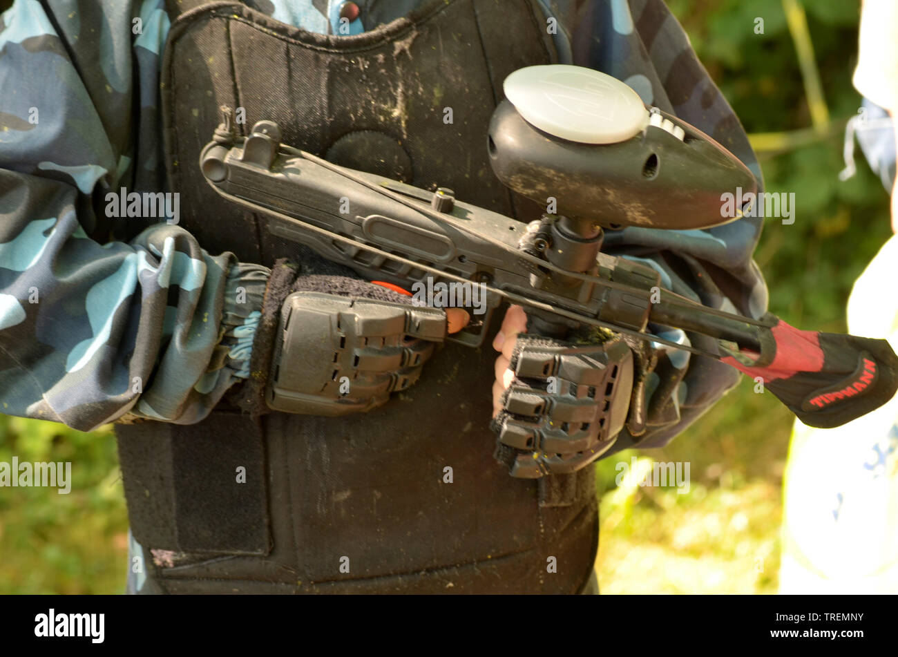 Paintball battle. Detail of the rifle held by a player: you can see the ...