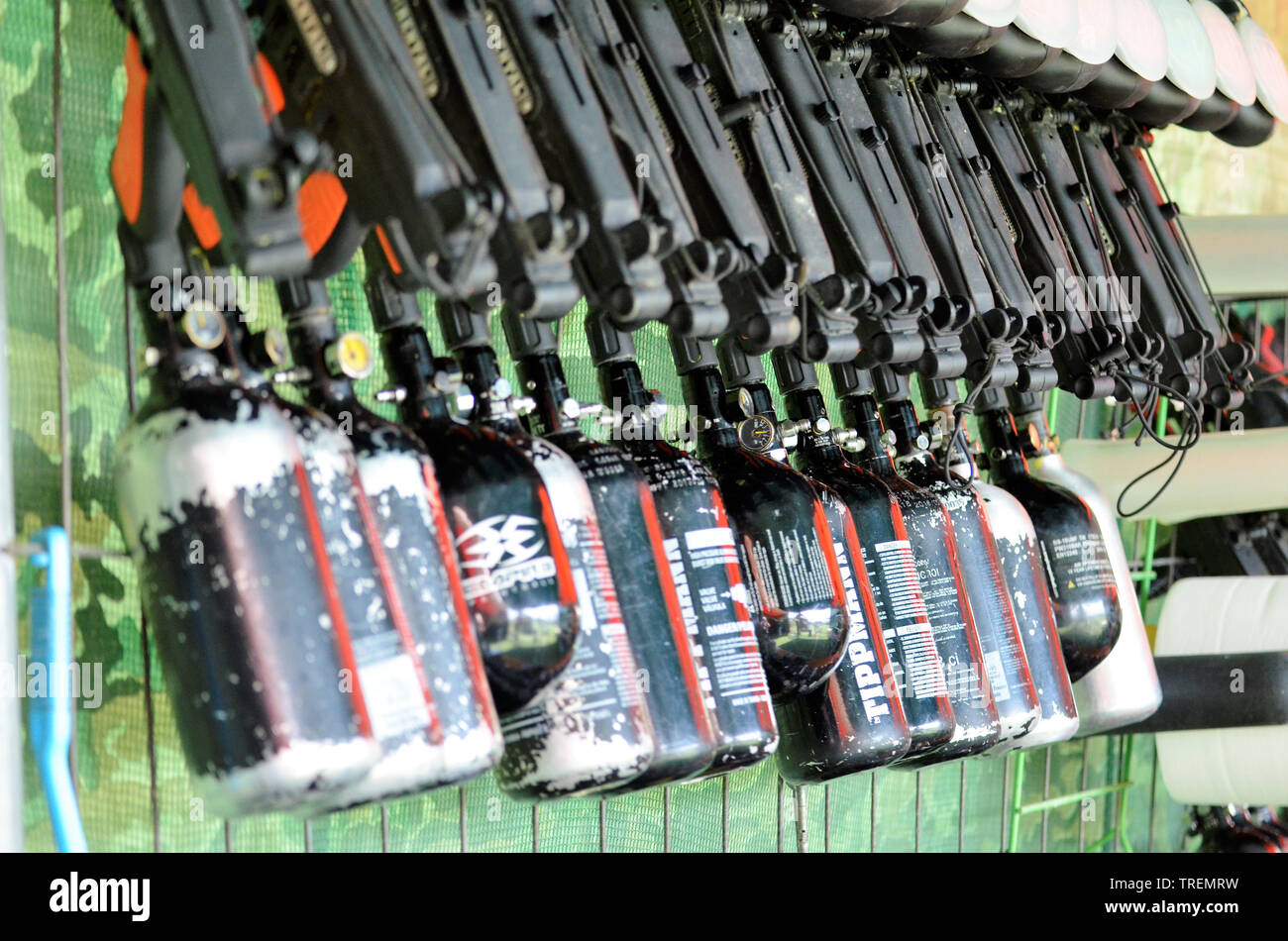 Paintball equipment. A rack packed with air guns. The gas-filled ...