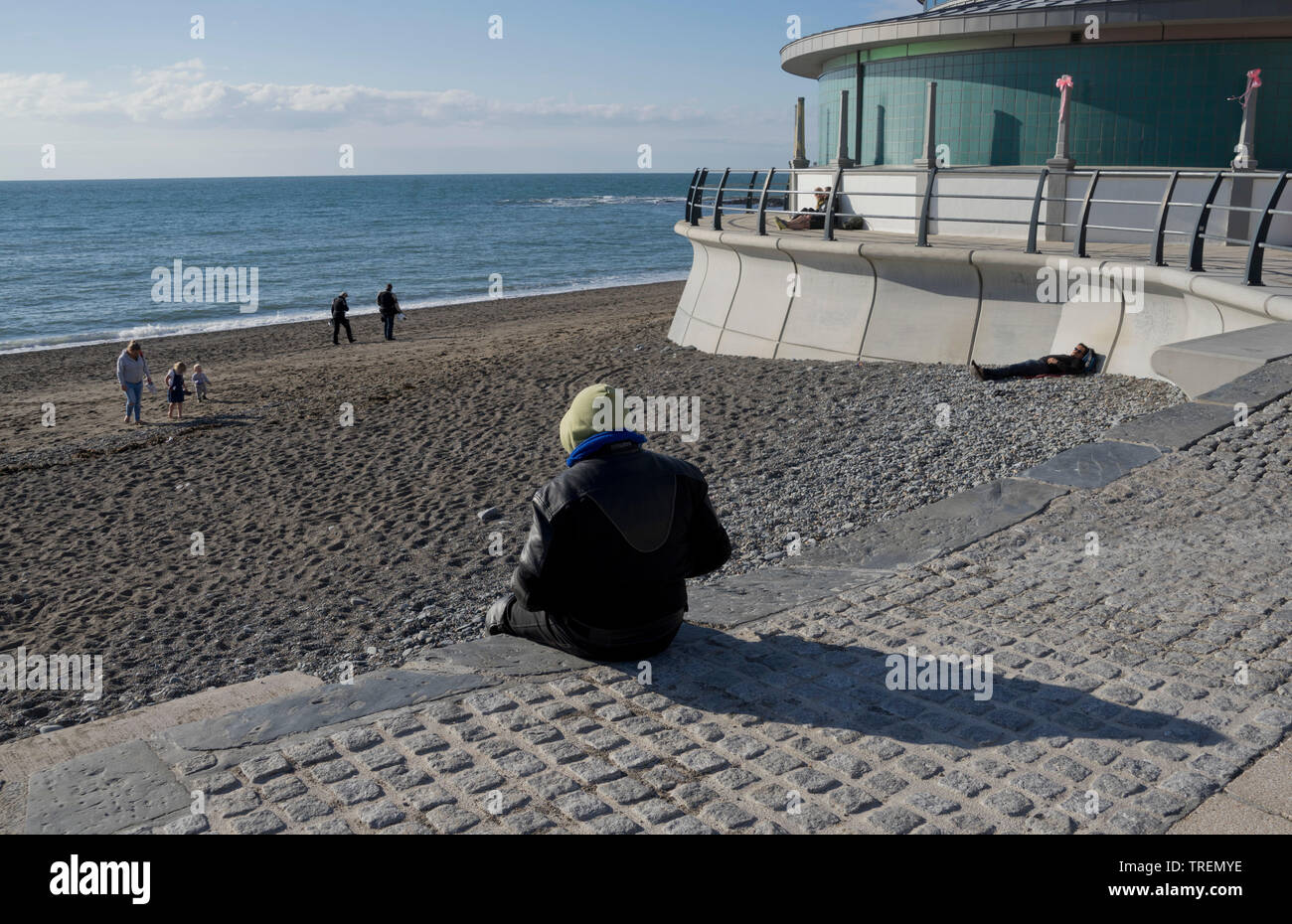 People enjoying the sun at the North beach promenade, Aberystwyth ...