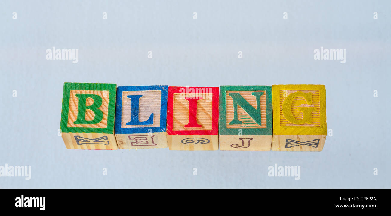 The term bling visually displayed in colored toy blocks on a clear ...