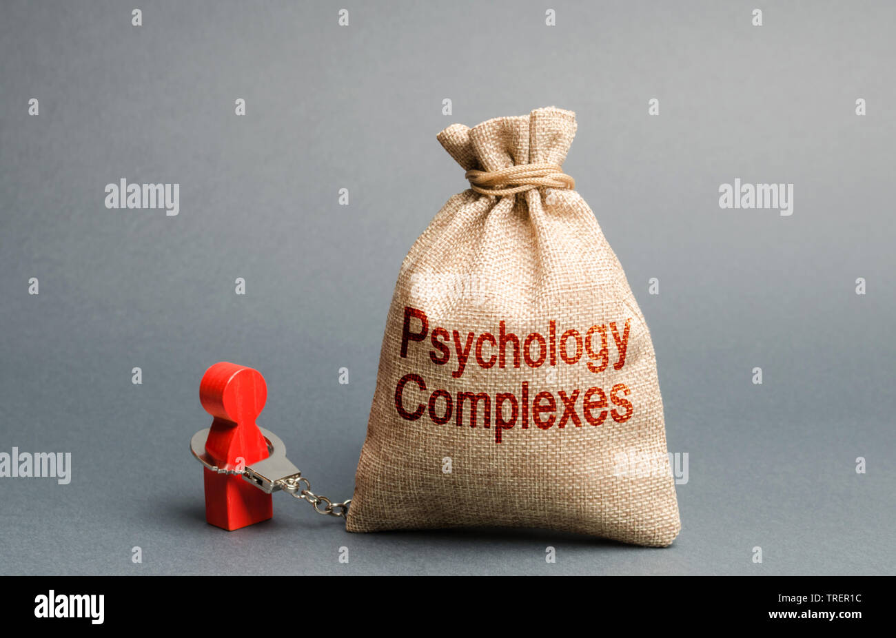 A person is handcuffed with a bag labeled psychological complexes ...