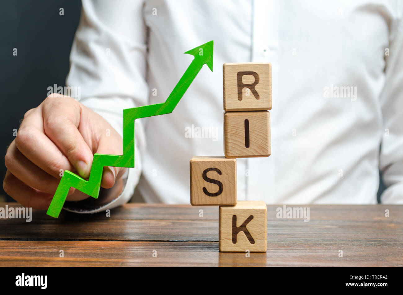 Businessman holding a green up arrow near the word Risk. Improving ...