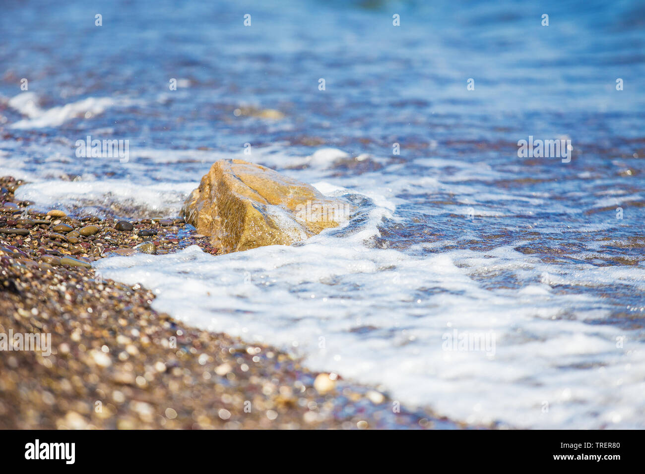 surf on seashore with stone Stock Photo - Alamy