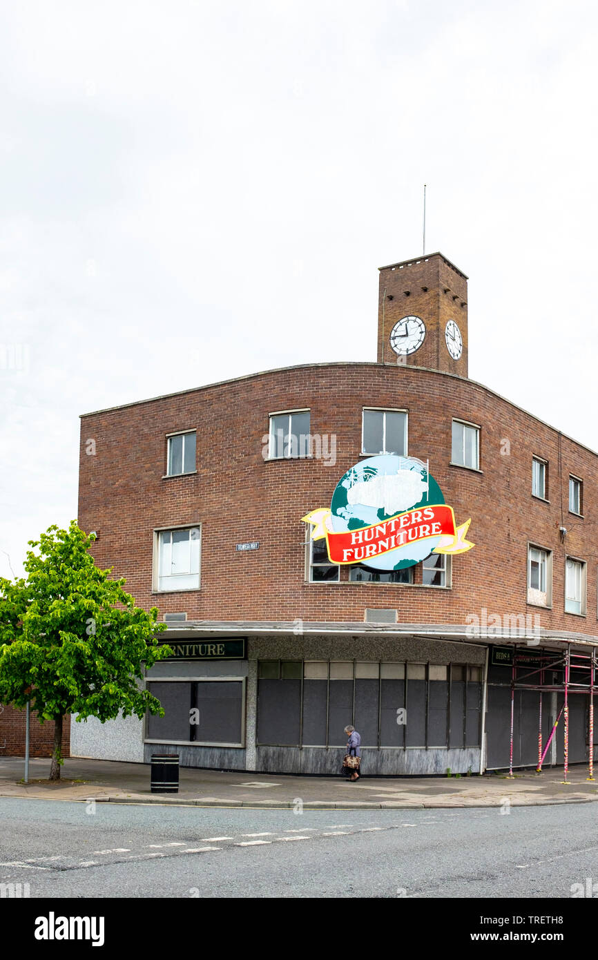 Clock tower with closed down and boarded up shops in town centre of ...