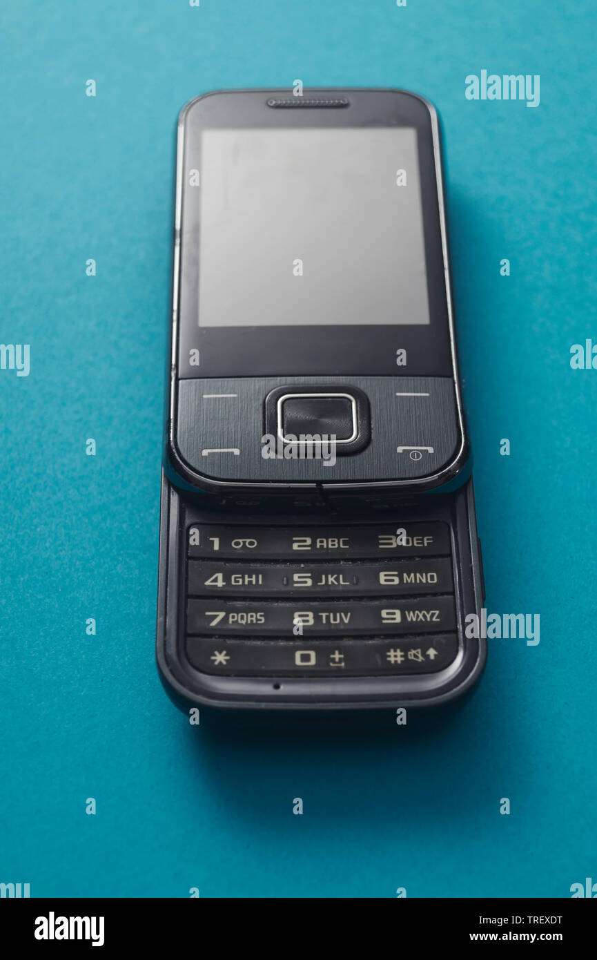 Old retro mobile phone on blue background, close up Stock Photo - Alamy