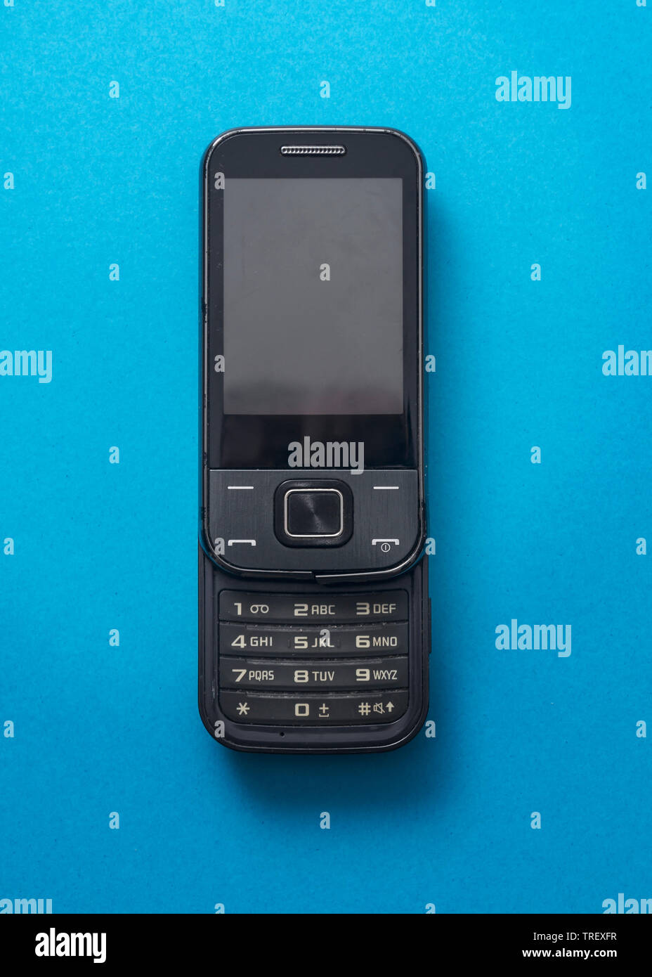 Old retro mobile phone on blue background, from above Stock Photo - Alamy