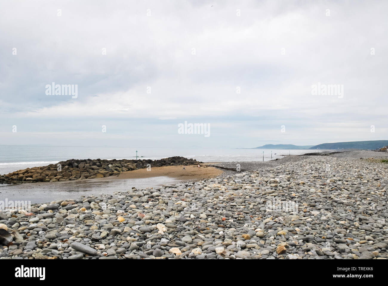 A beach scene in Borth, Wales, Uk showing rocks placed as part of Borth ...