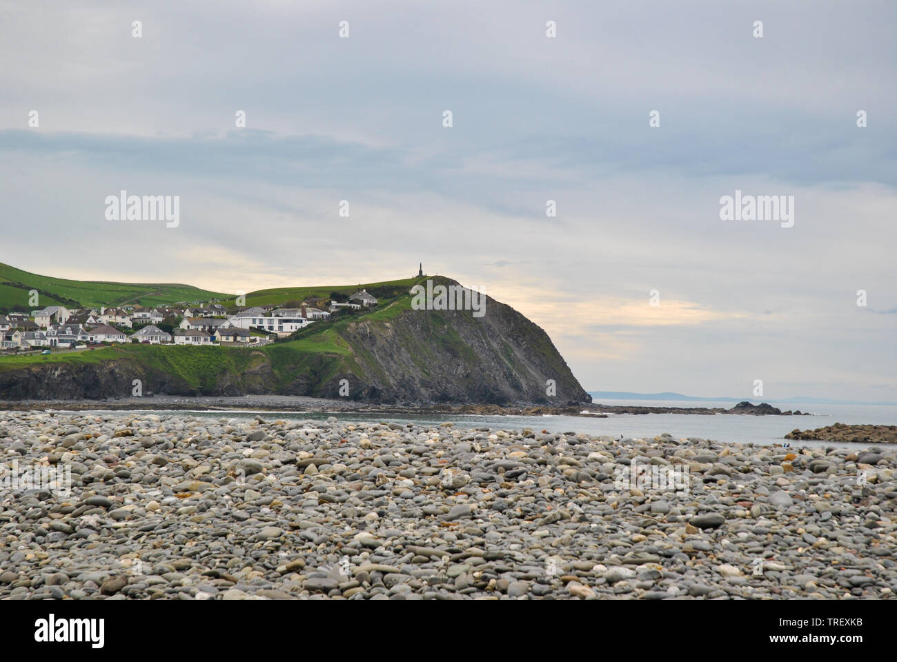 A view of the beach and cliffs in background showing Borth War Memorial ...