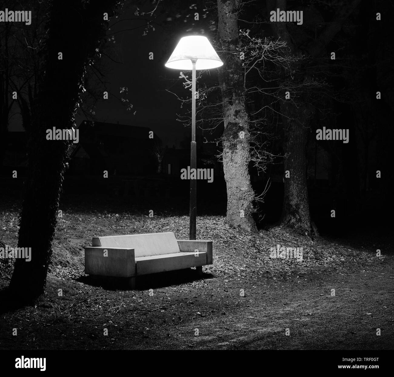 A bench that looks like a sofa under a street lamp that looks like a ...
