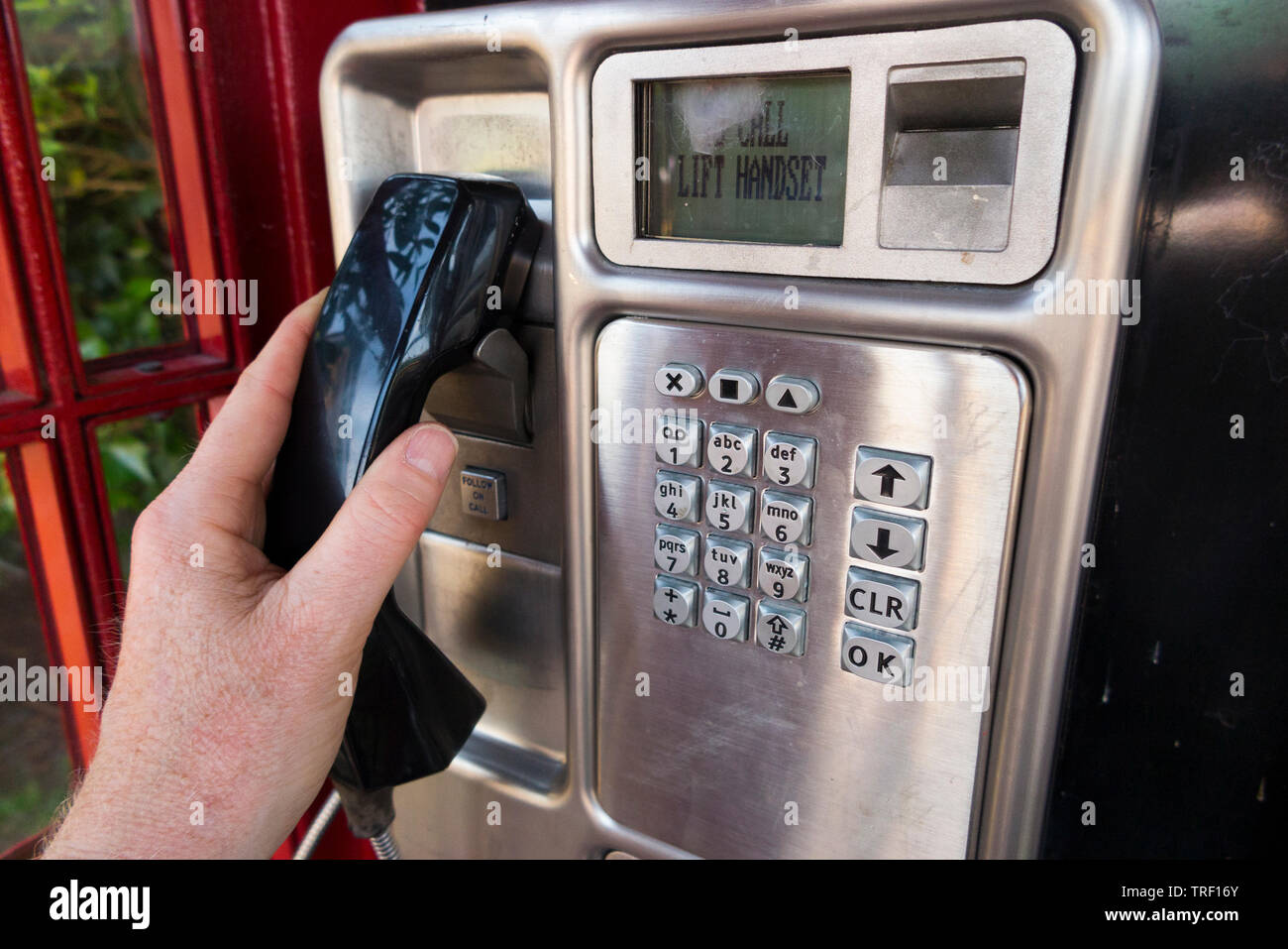 Person lifting the handset and preparing to dial a number / dialling ...