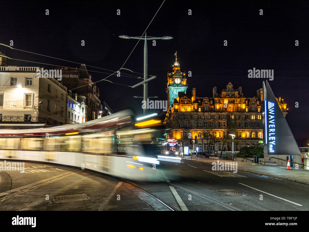 The swish of Edinburgh trams passing by on Princes Street by night ...