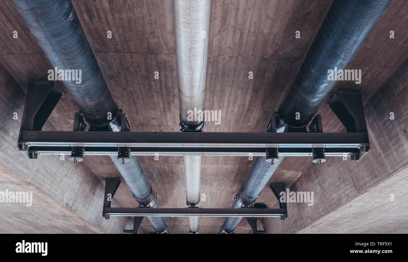 Pipes under a concrete bridge with dampers and steel support to keep it ...