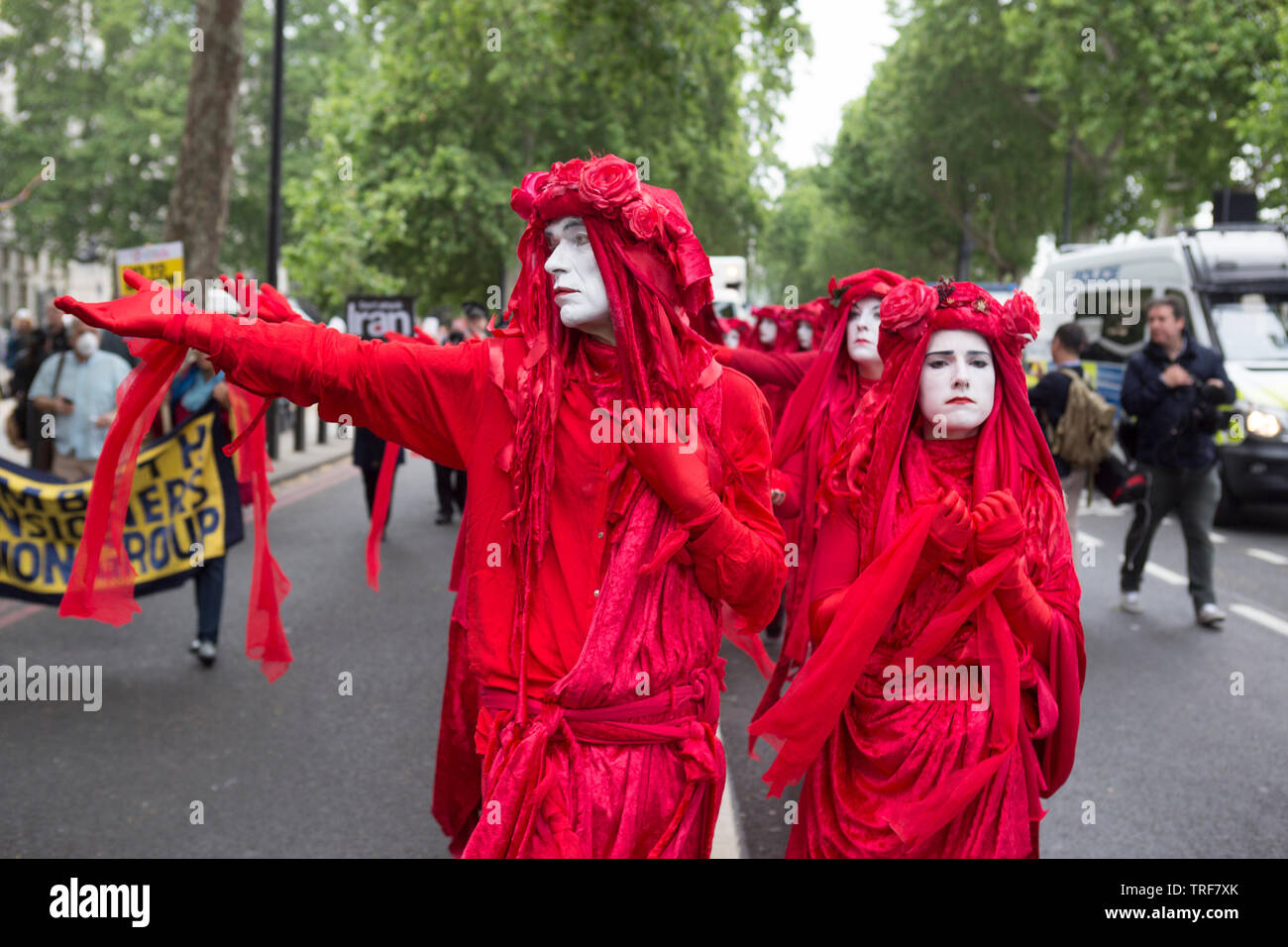 Mime artists dressed in red with painted white faces protesting in ...