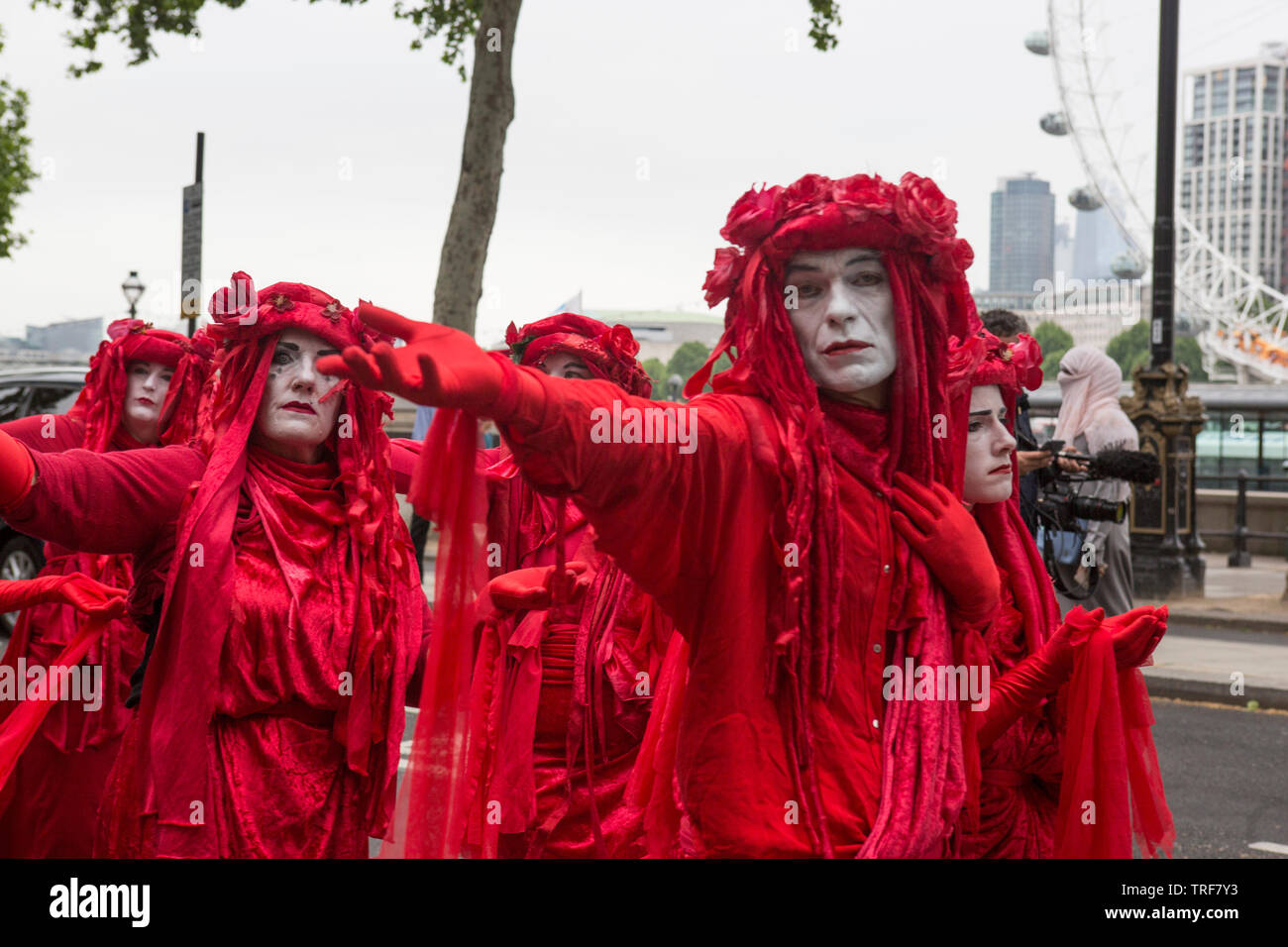 Mime artists dressed in red with painted white faces protesting in ...