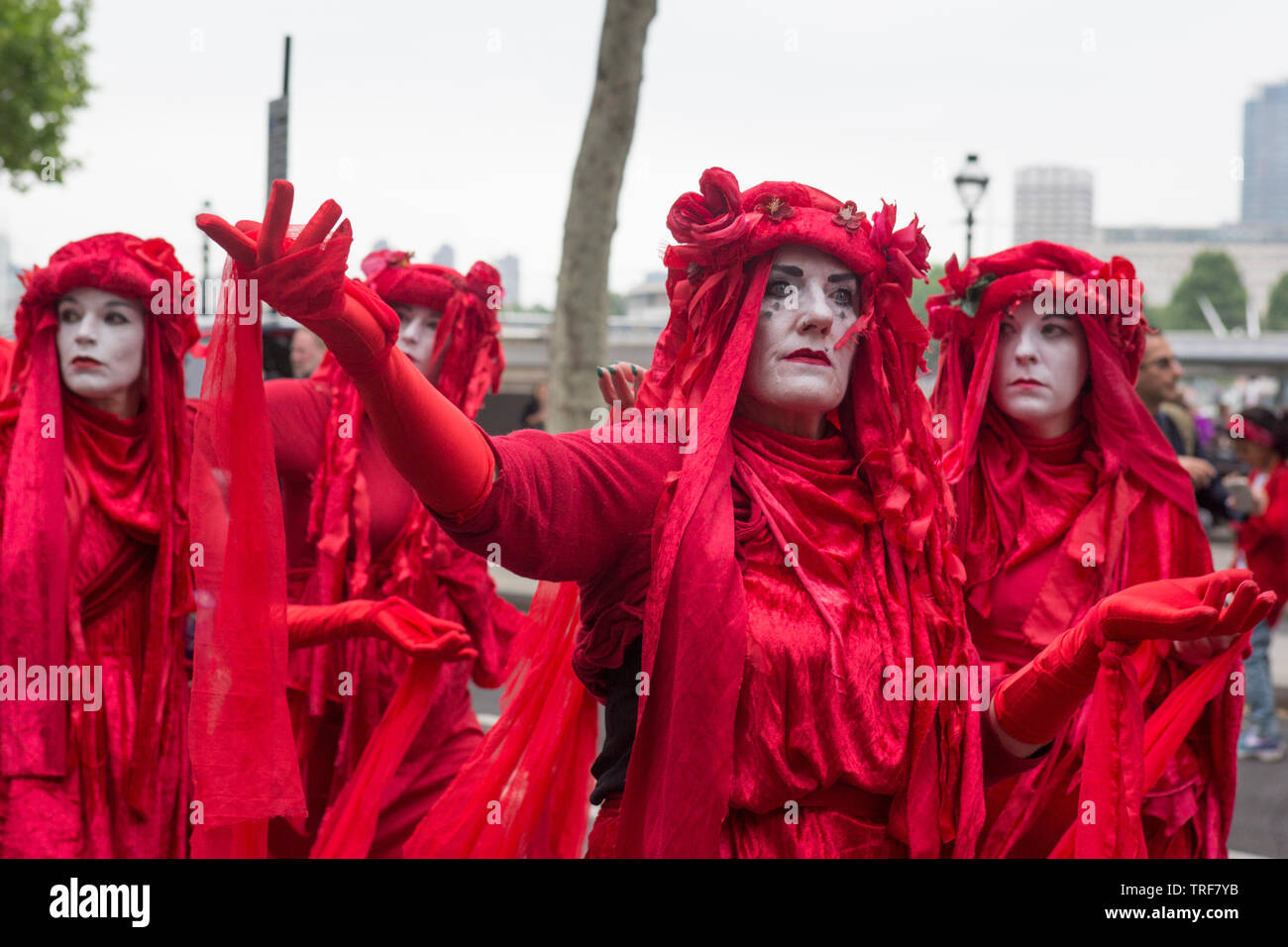 Mime artists dressed in red with painted white faces protesting in ...