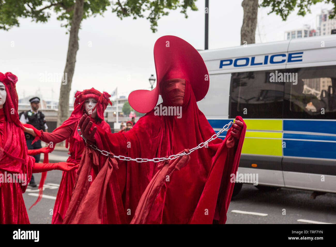 Mime artists dressed in red with painted white faces protesting in ...
