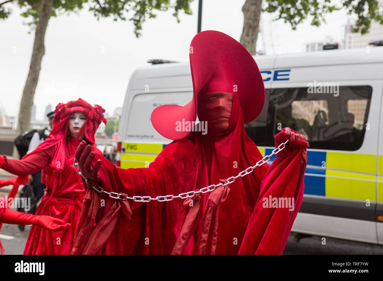 Mime artists dressed in red with painted white faces protesting in ...