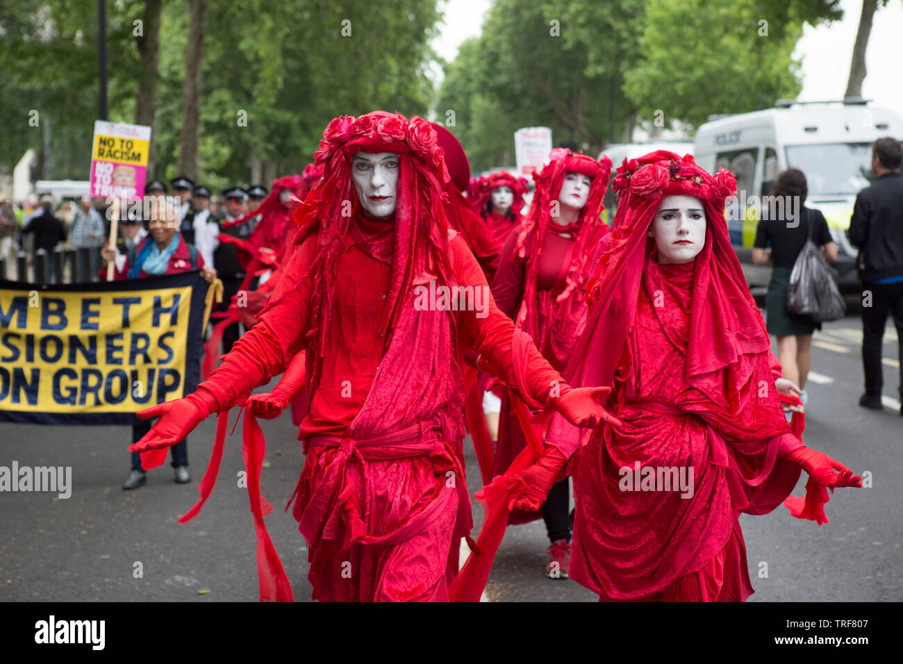 Mime artists dressed in red with painted white faces protesting in ...