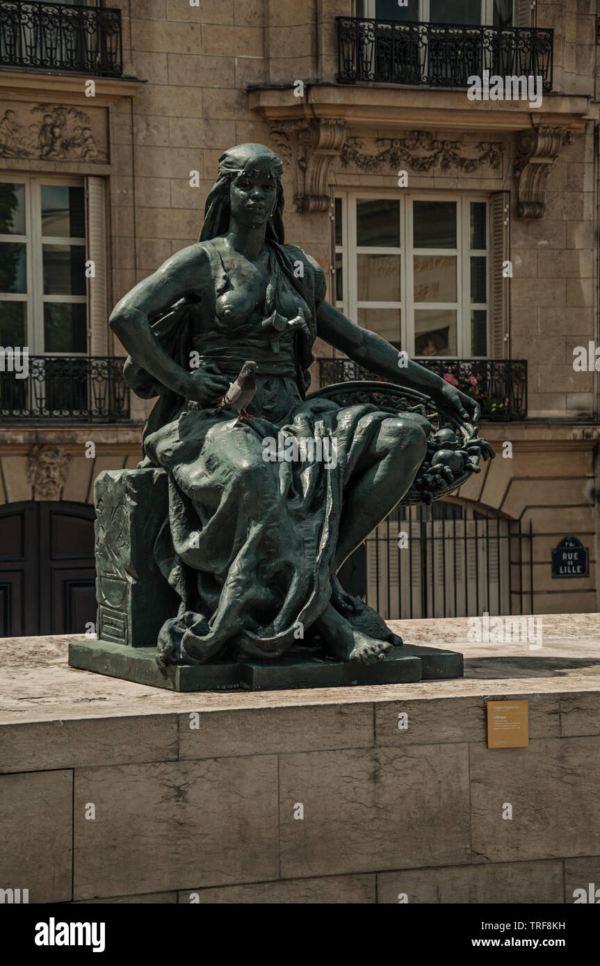 Statue of woman sitting in front of building in a sunny day at Paris ...