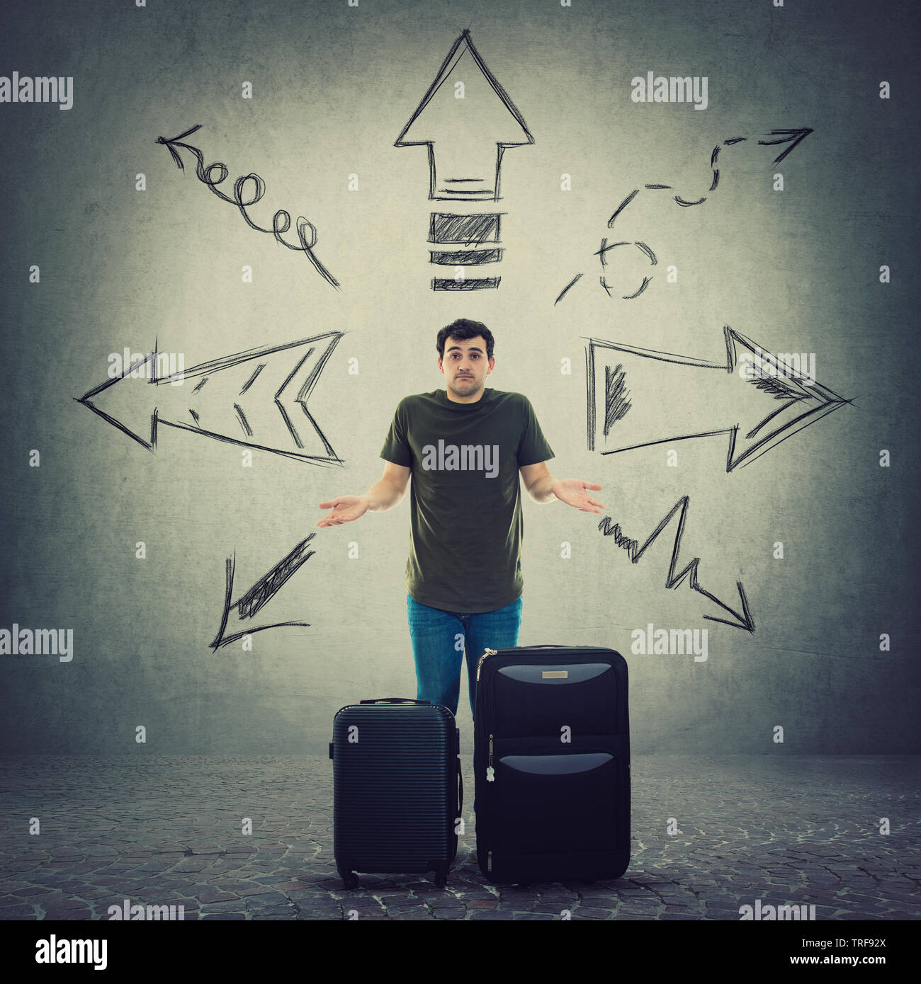 Confused young man traveler standing behind his luggage don't know ...