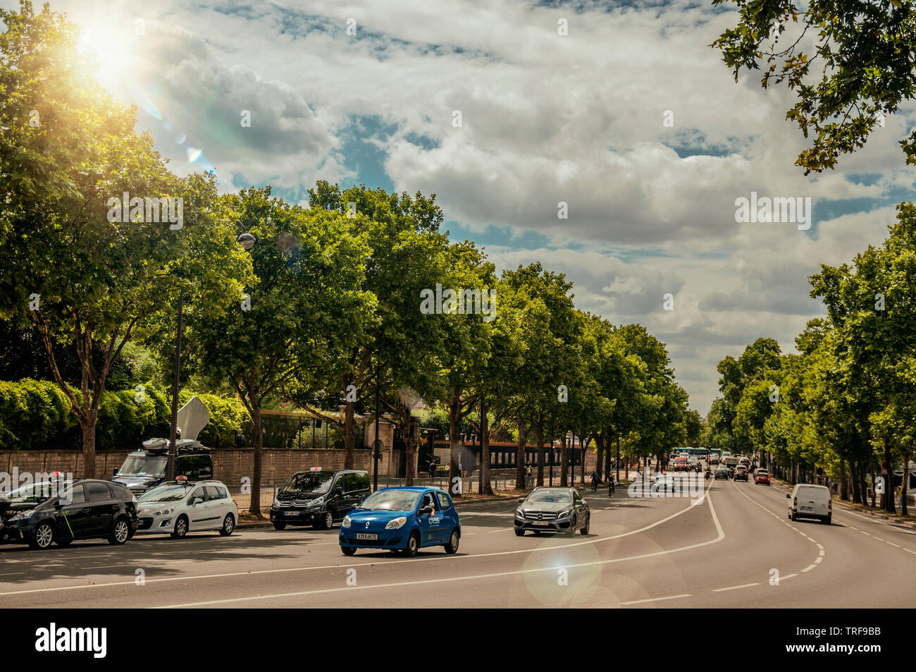 Cars on a tree-lined street in sunny day at Paris. One of the most ...