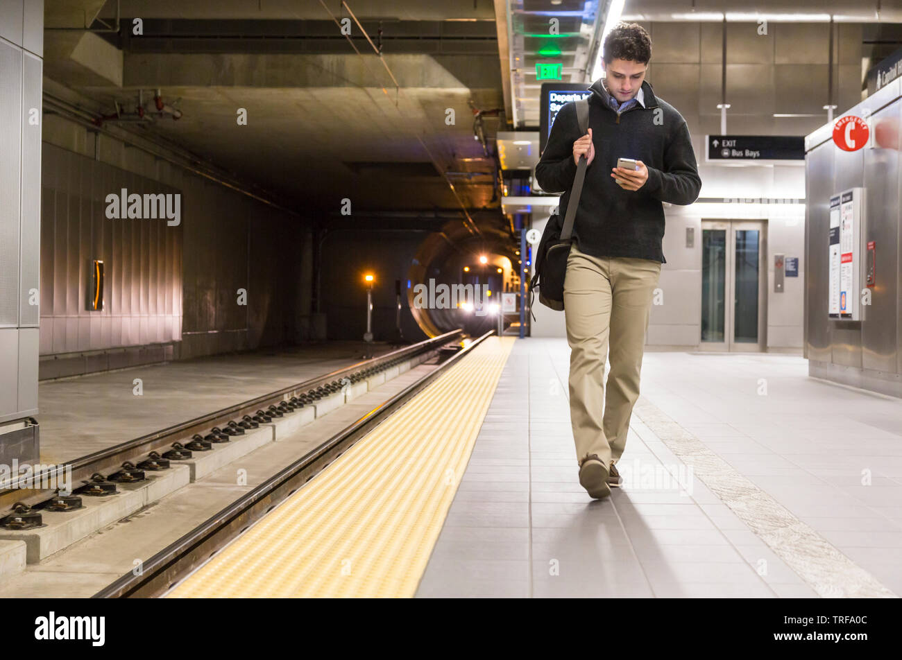 Professional man commuter with cell phone walking on subway station ...