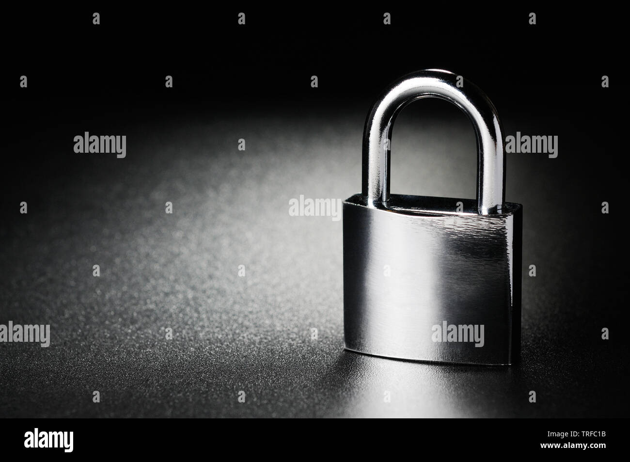 Steel padlock on the black textured background Stock Photo - Alamy
