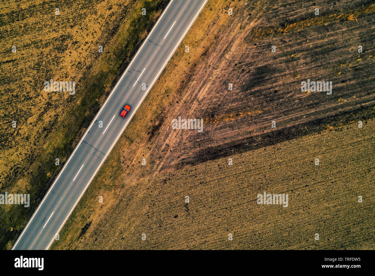 Single red car on the road, through plain countryside aerial view from ...