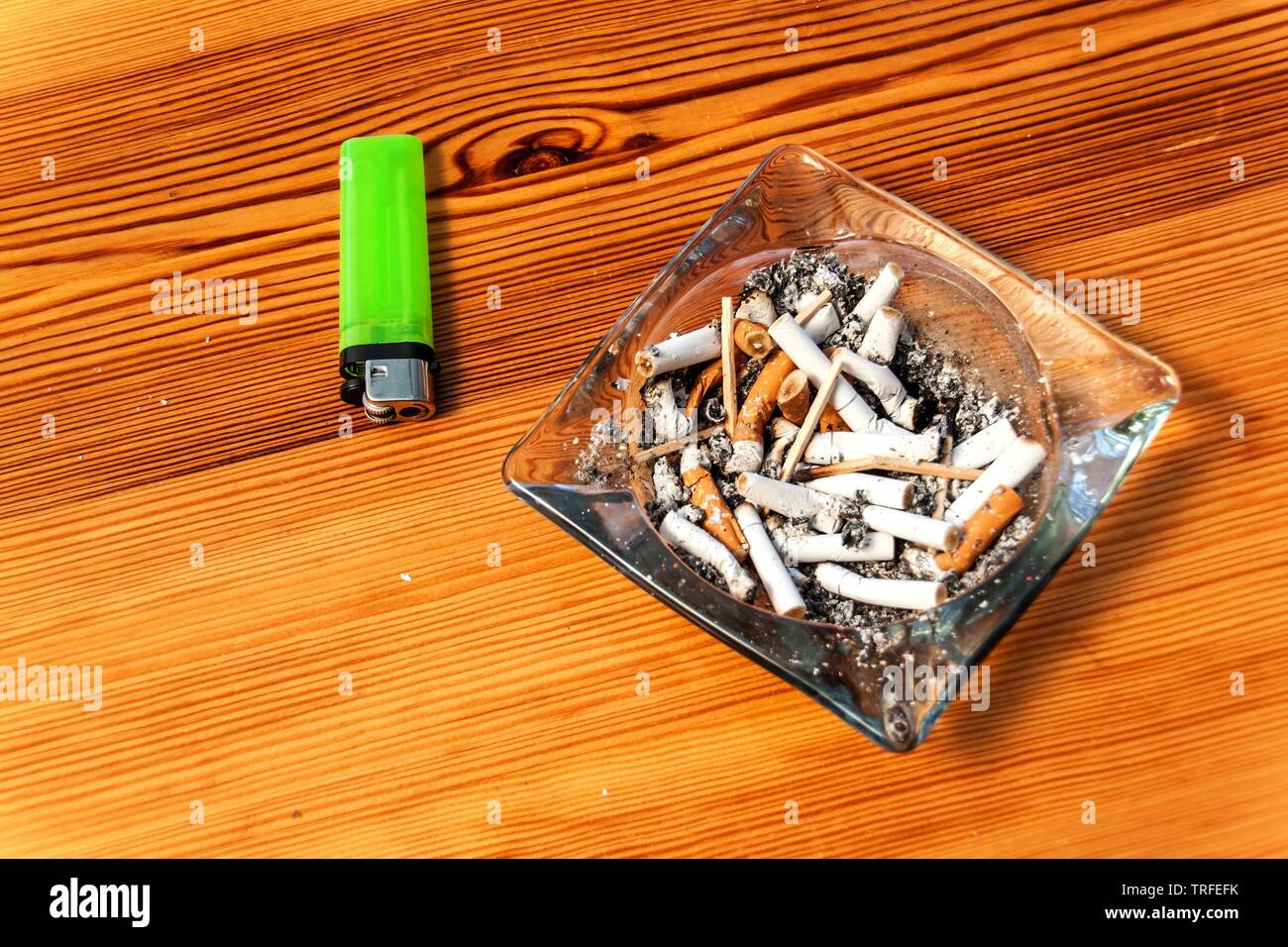 Ashtray with cigarettes on the table. Lighter and cigarettes. Lung ...
