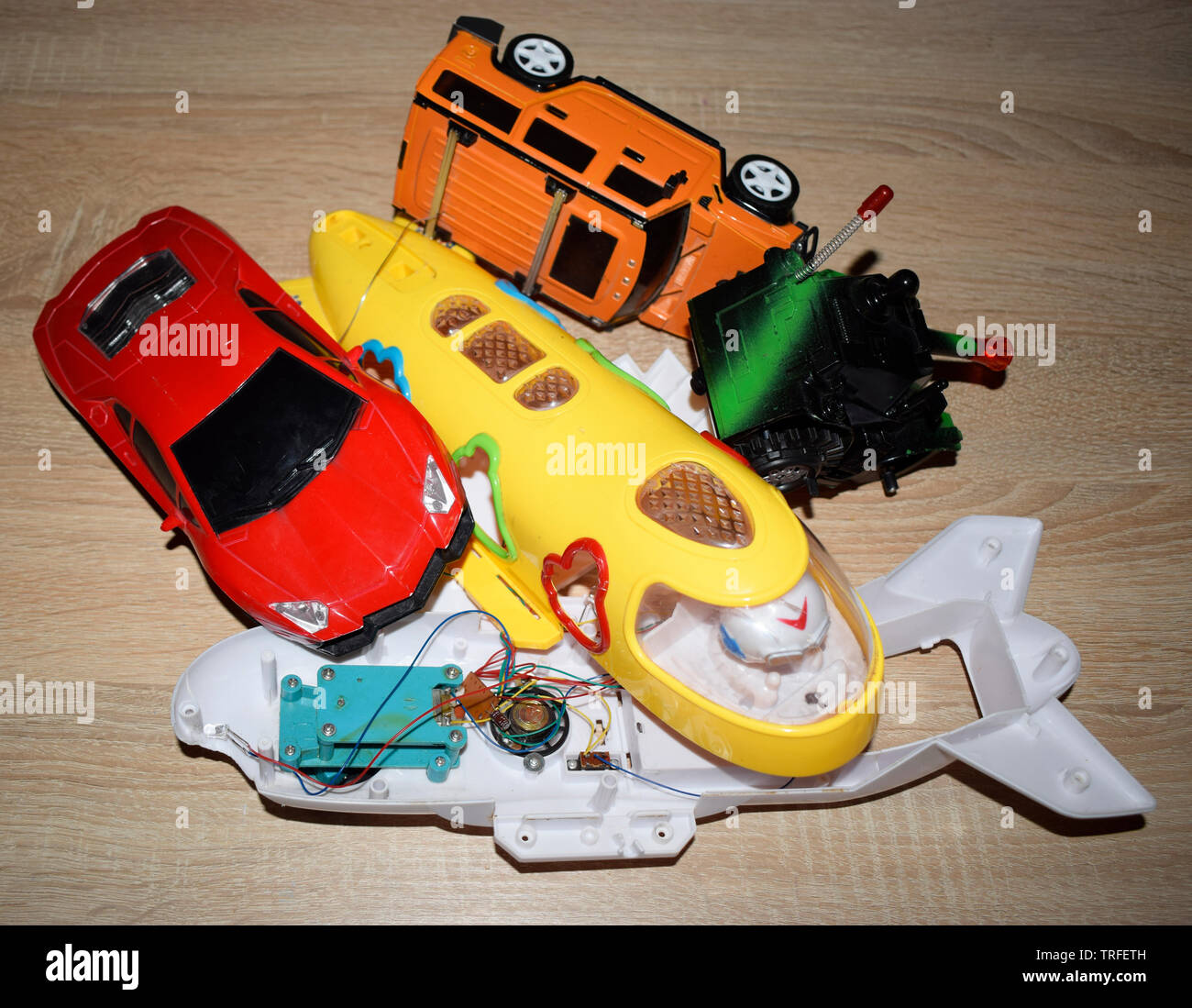 A dismantled toy cars and airplane divided in several pieces on wooden ...