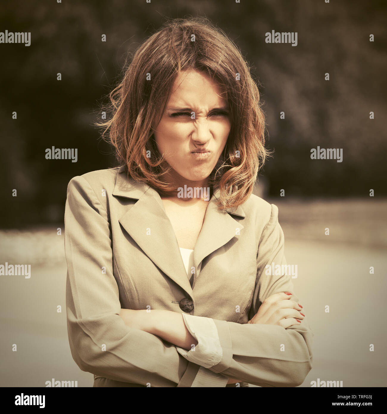 Angry young woman walking on city street Stylish fashion model in gray ...