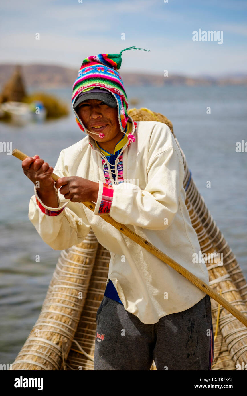 Uros man managing a totora or reed raft made by him and his family on ...