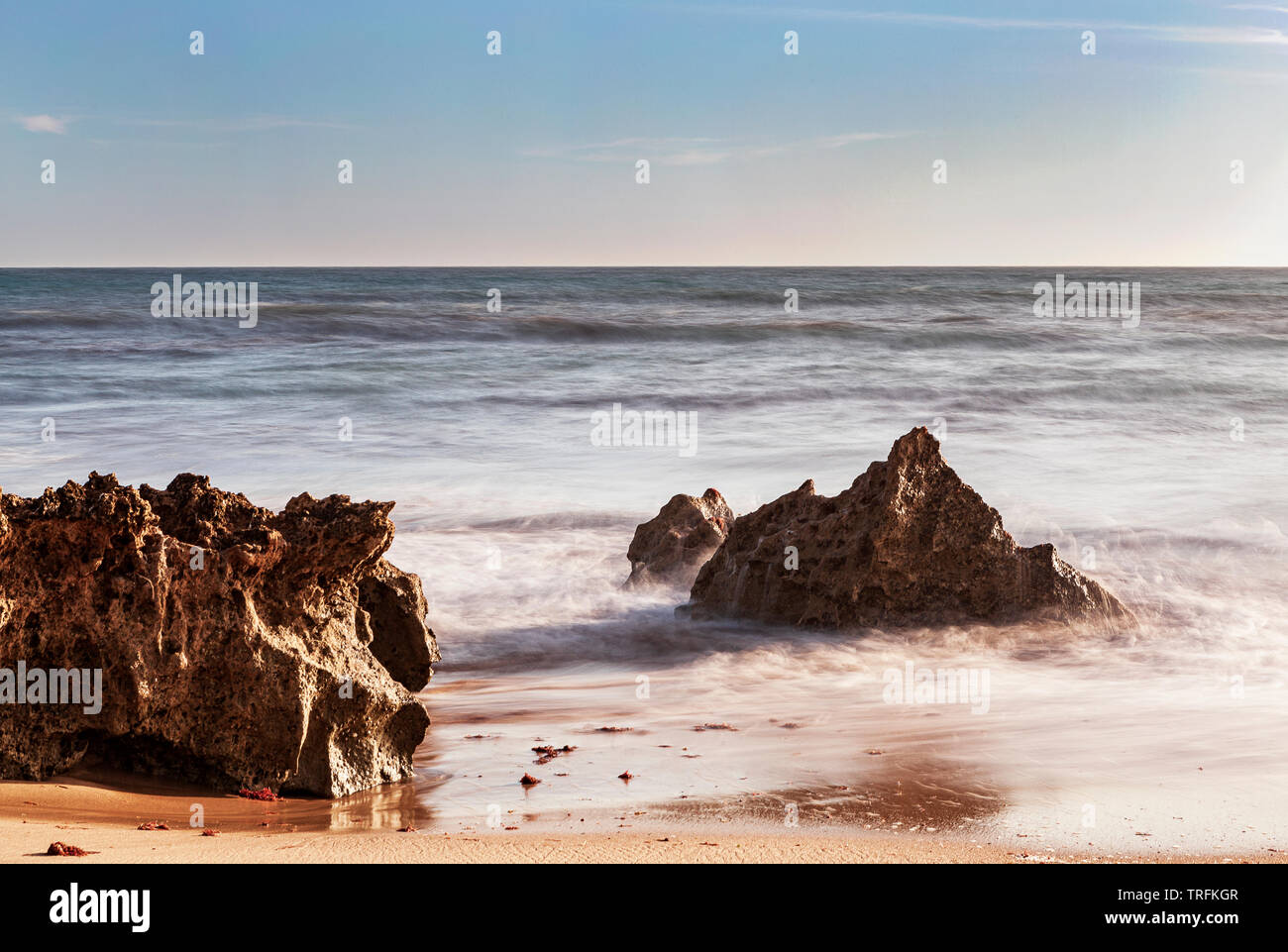 Rocks on the surf of the beach waves Stock Photo - Alamy
