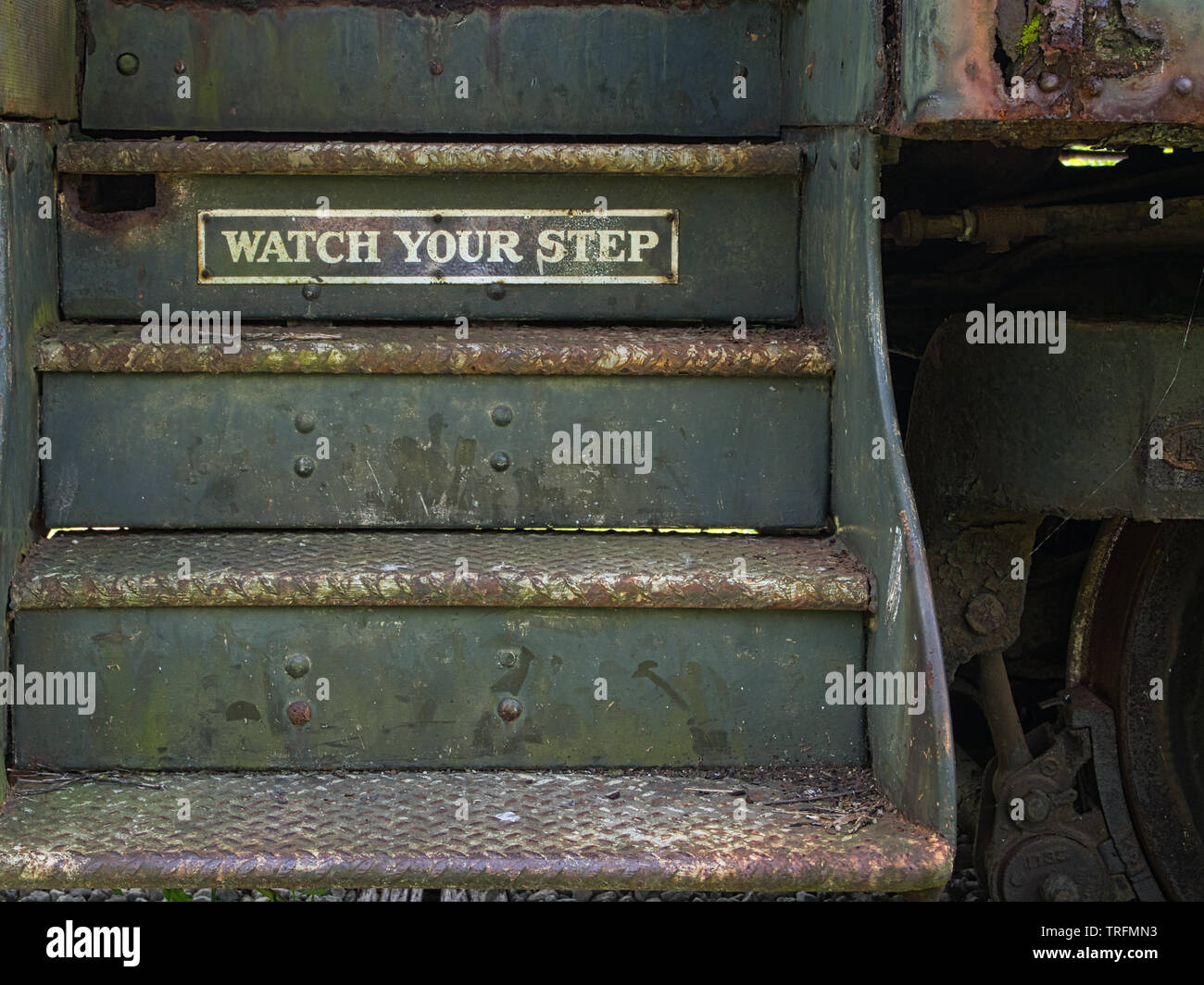 steps into a passenger railway car with a watch your step warning sign ...