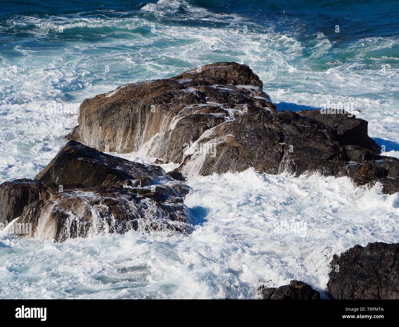 Ocean water cascading over rocks Stock Photo - Alamy