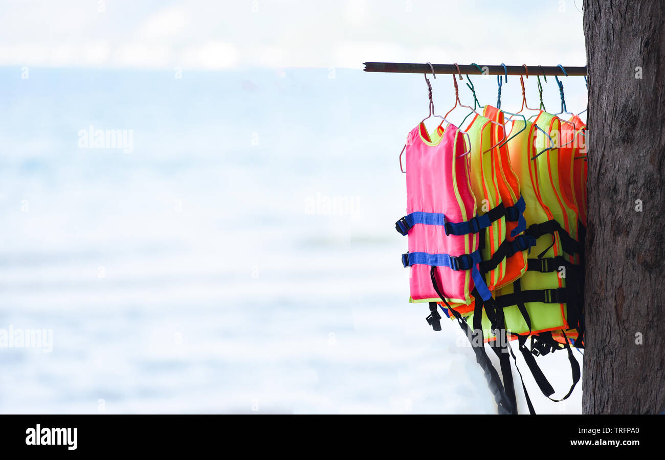 Life jacket safety equipment hang on clothes line in the sea background ...