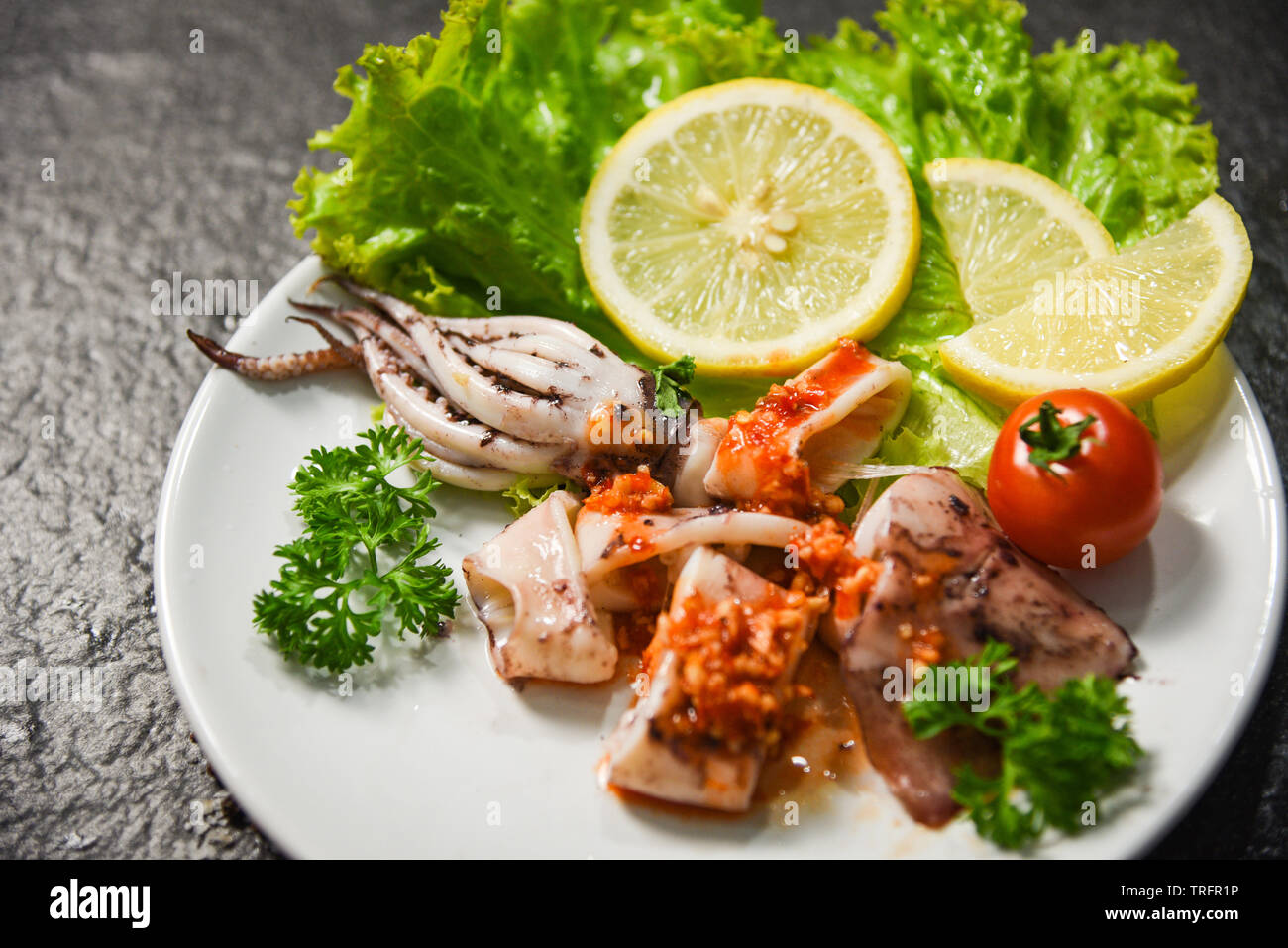 Grilled squid slice on plate in the seafood restaurant / Squid salad ...