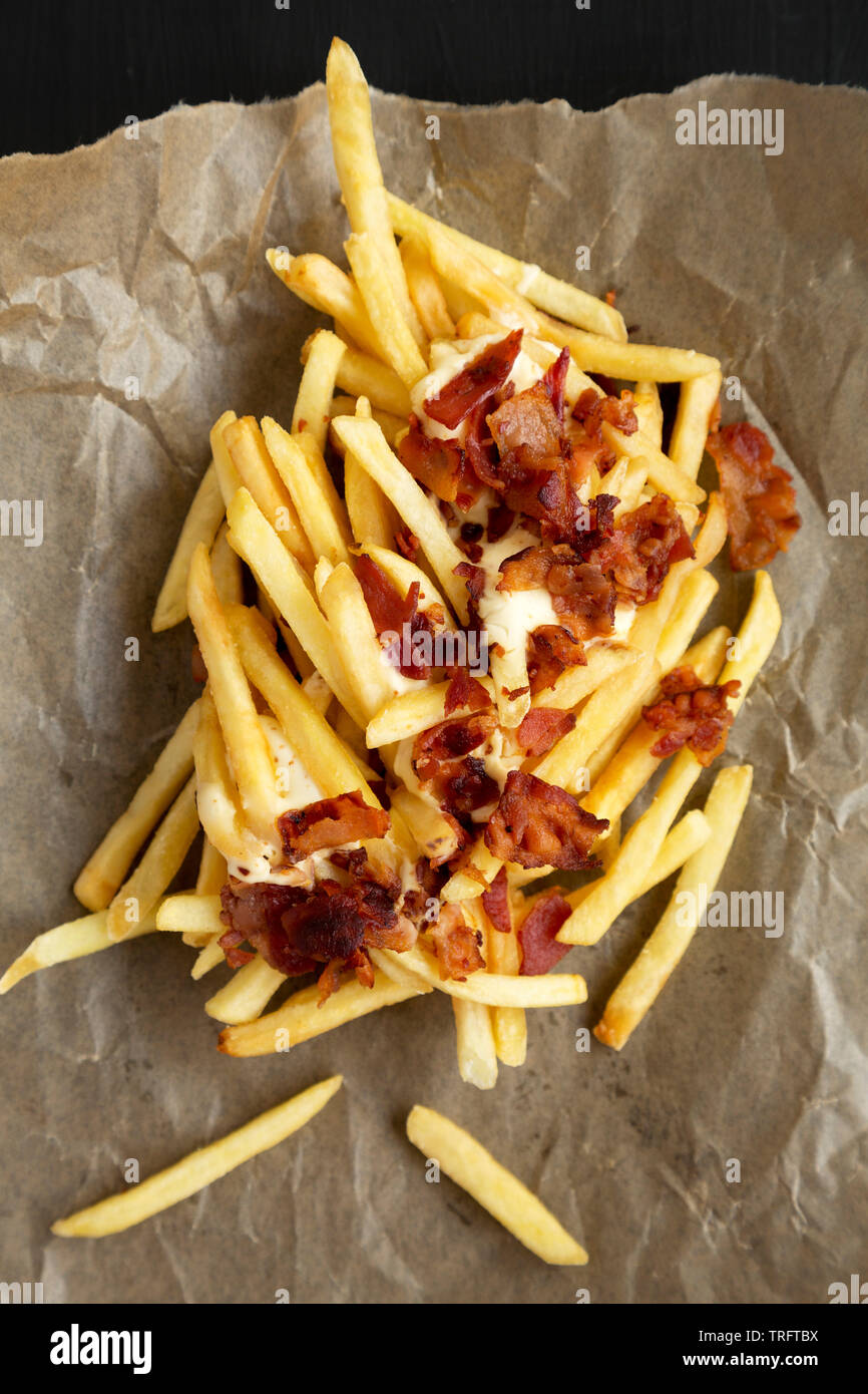 French fries with cheese sauce and bacon, top view. Flat lay, from ...