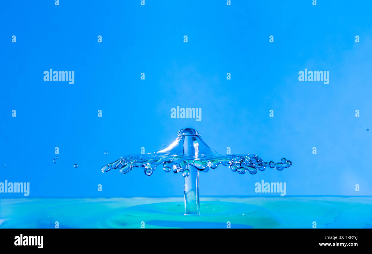 water drop falling and impacting a body of water after hitting the ...