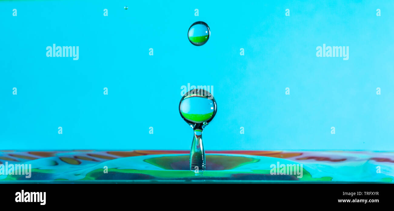 water drop falling and impacting a body of water after hitting the ...