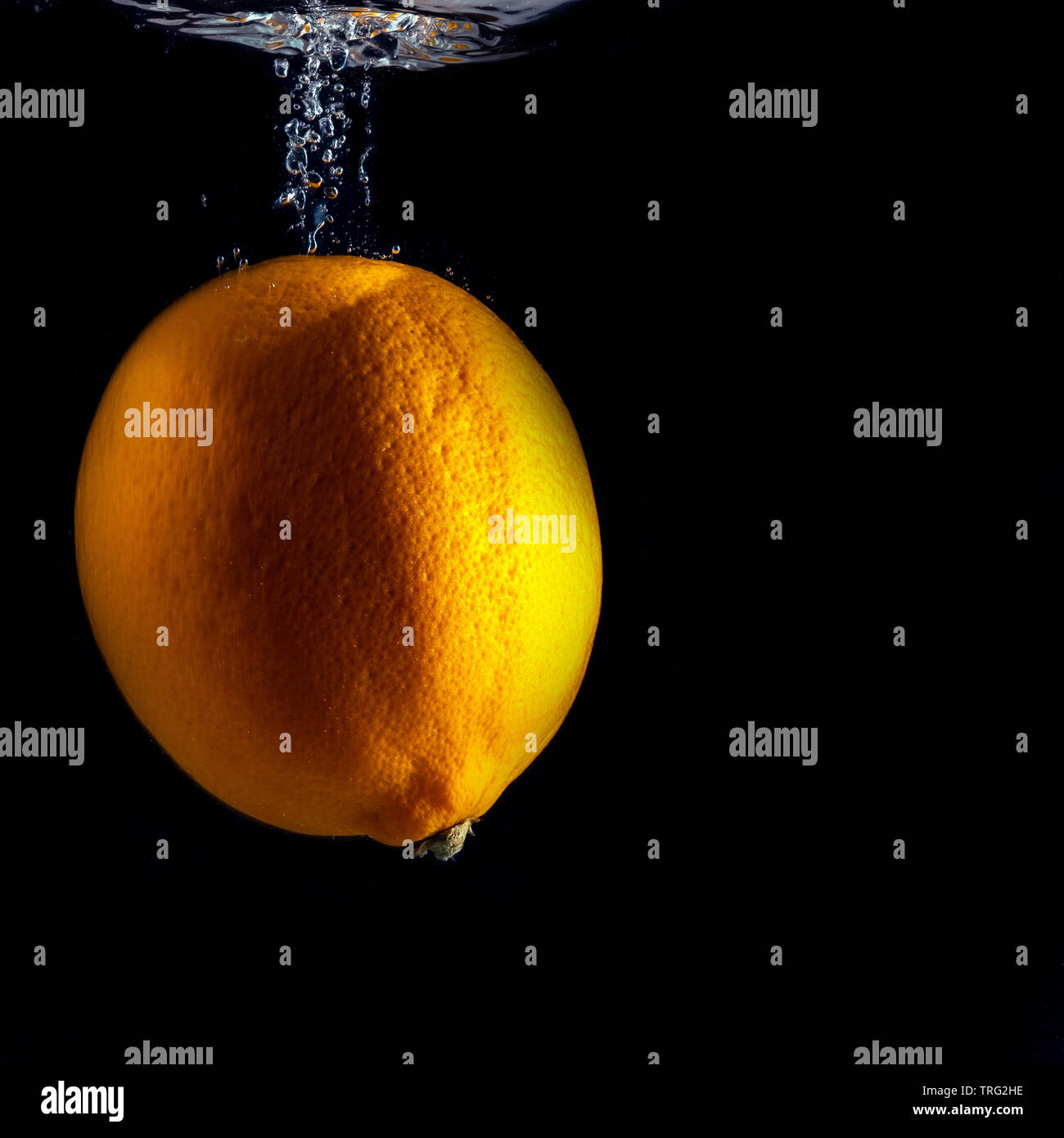 yellow juicy lemon falls into the water with a splash Stock Photo - Alamy