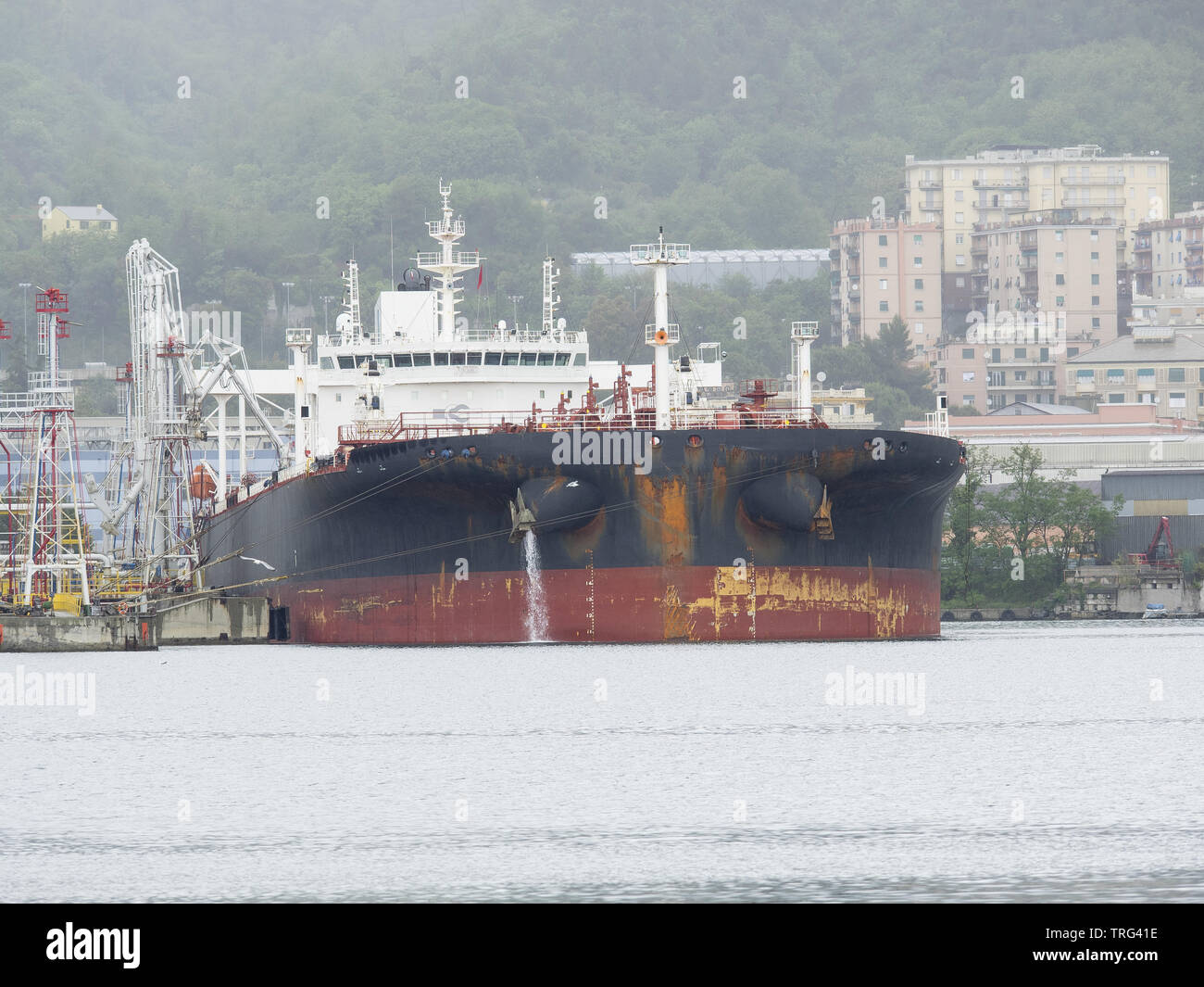 big crude oil chemical tanker discharge bilge water in port, buildings ...