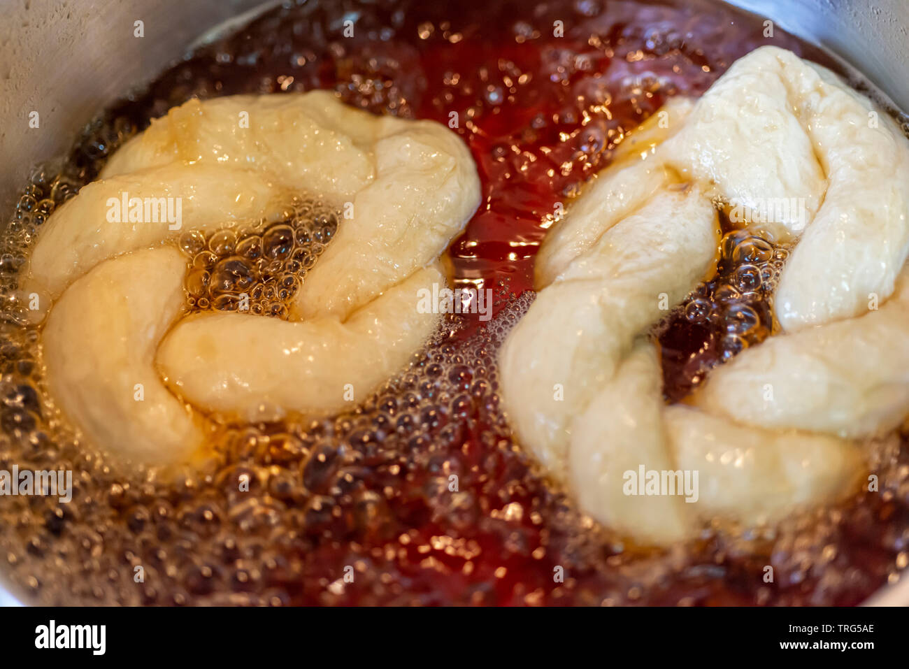 Boiling american bagel before being baked Stock Photo - Alamy
